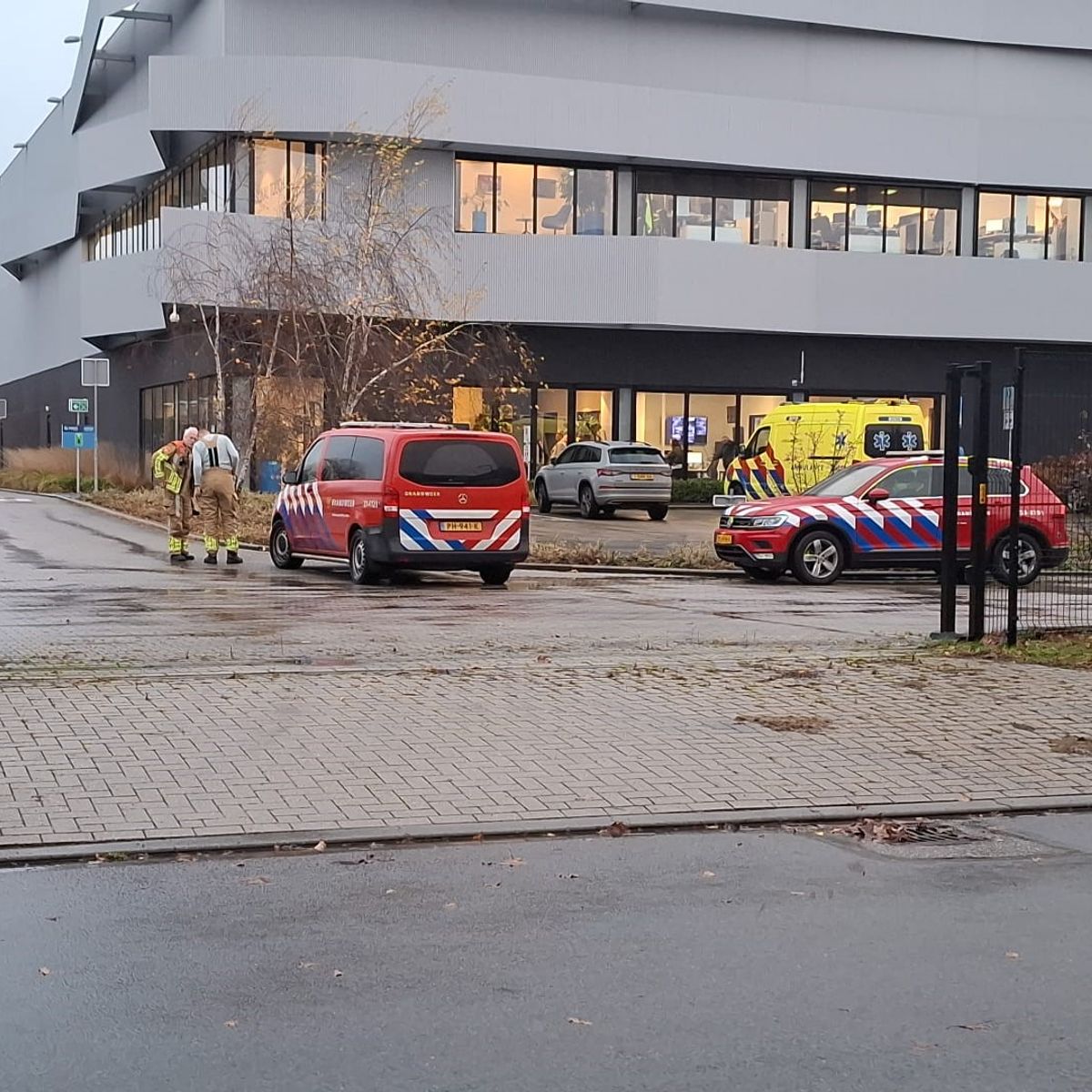 Personeel helpt collega na incident met bijtende stof bij logistiek ...