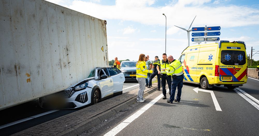 Vrachtwagen kantelt op snelweg en losgekomen container plet auto - Rijnmond