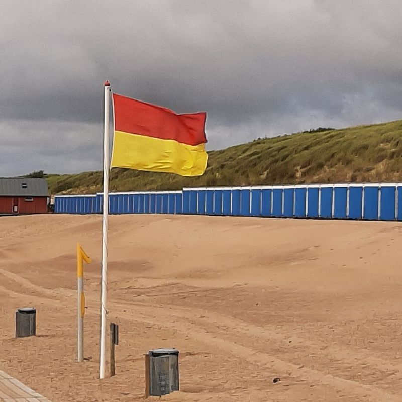 Een rode, gele, rood-gele of paarse vlag op het strand: 'Is dit ...