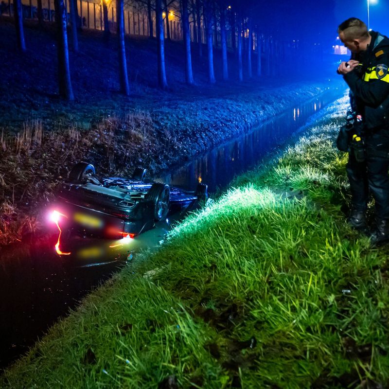 Auto belandt op de kop in smalle sloot, inzittenden onderkoeld ...