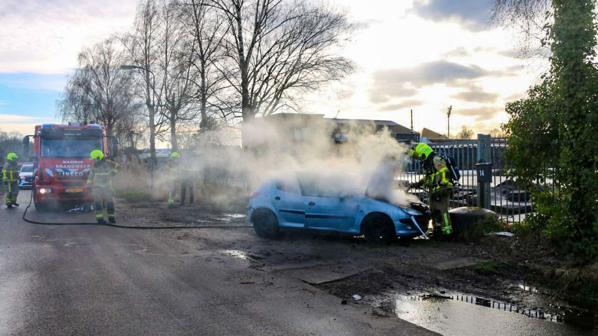 Plots ziet de bestuurder rook uit het dashboard van zijn auto komen ...