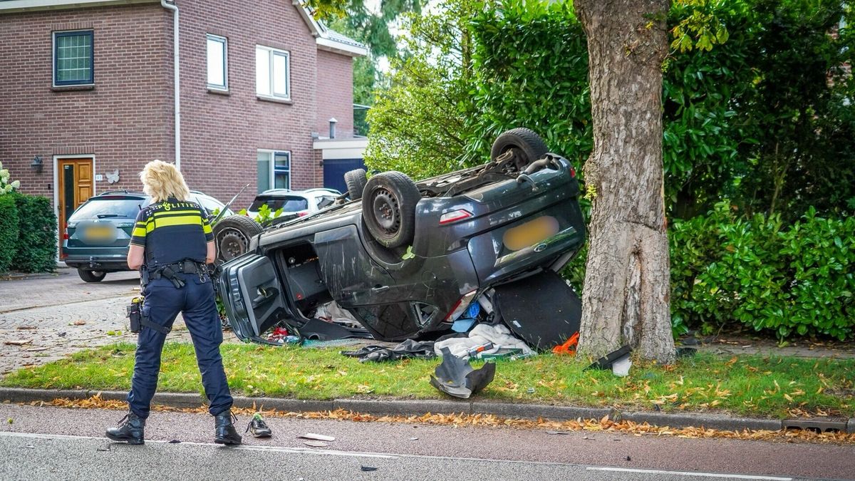 Auto rijdt lantaarnpaal omver in Emmen en belandt op de kop op de stoep ...