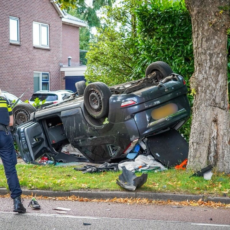 Auto rijdt lantaarnpaal omver in Emmen en belandt op de kop op de stoep ...