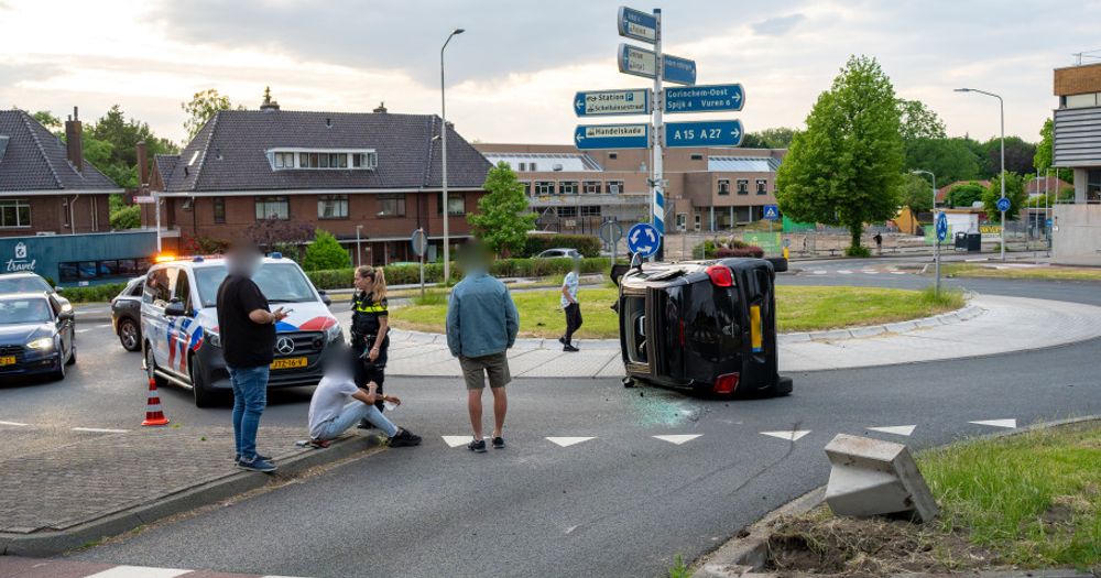 Auto raakt betonblok en belandt op z'n kant op rotonde - Rijnmond