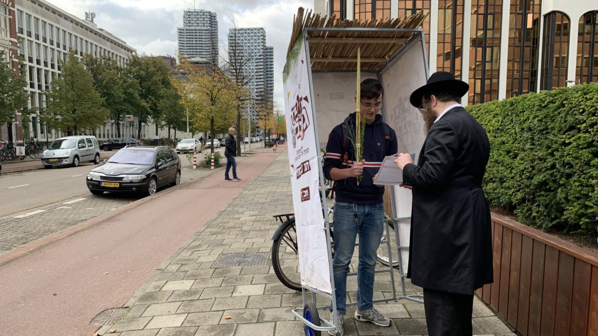 Rabbijn met loofhut achter fiets door Den Haag voor religieus feest ...