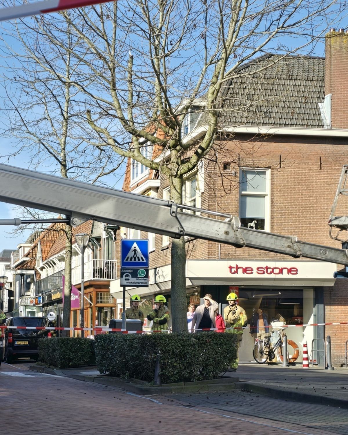 Hoogwerker kantelt en valt tegen gevel van winkel aan - Omroep West