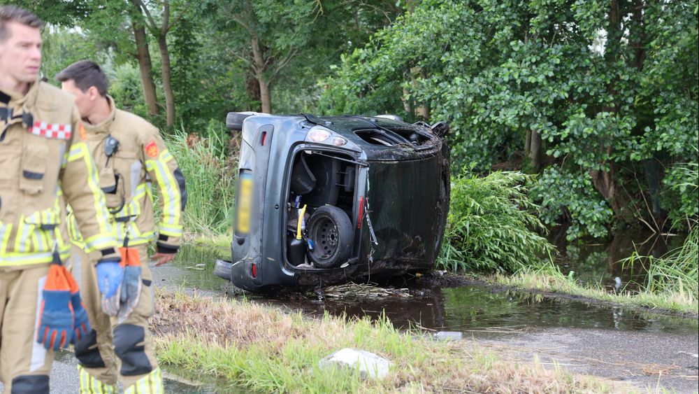 Auto slaat over de kop bij ongeluk, duikers zoeken in water - Omroep West