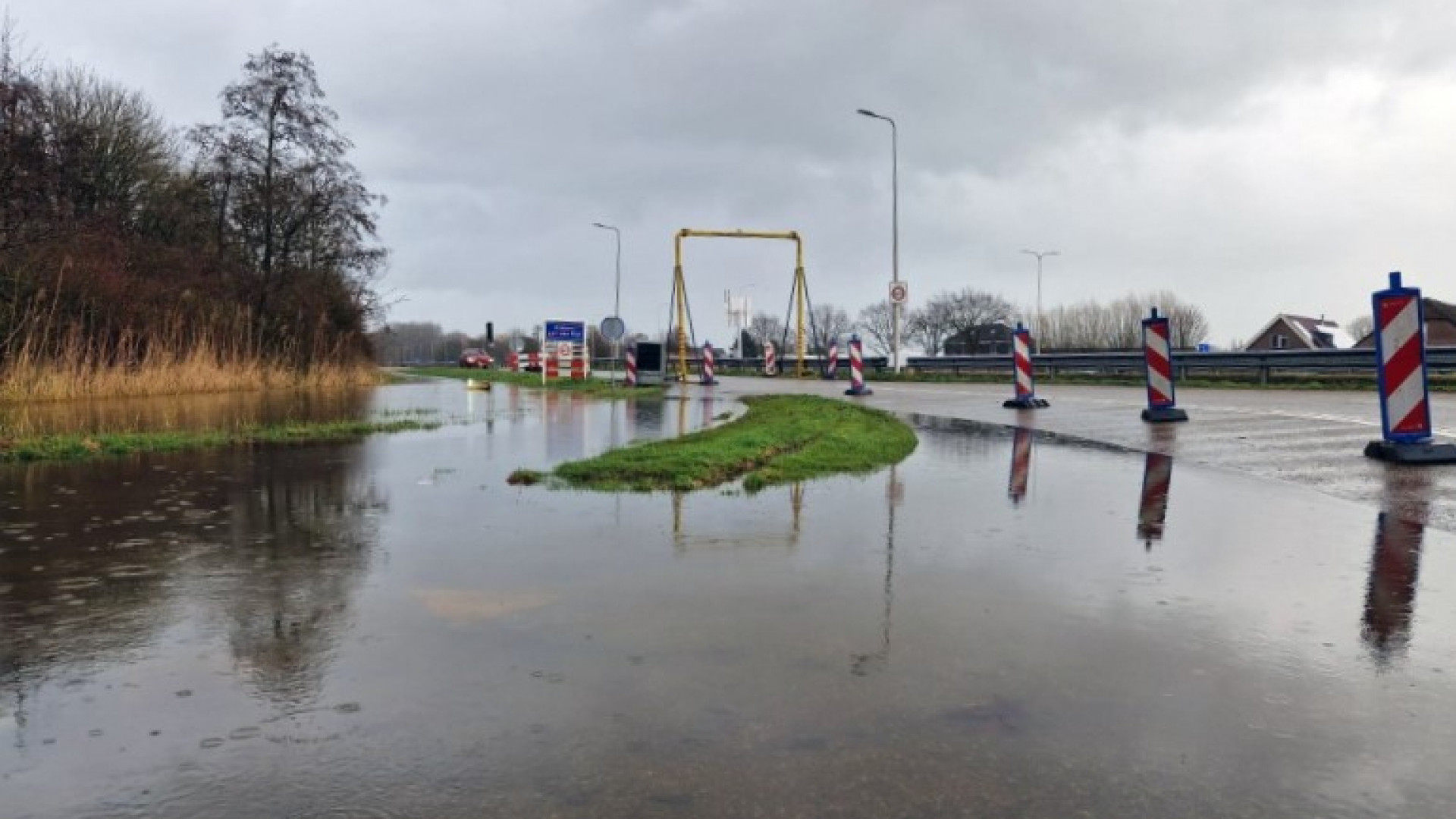 Sloot is overstroomd door hoog water, weg dicht en noodpomp geplaatst ...