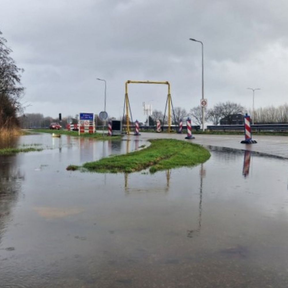 Sloot is overstroomd door hoog water, weg dicht en noodpomp geplaatst ...