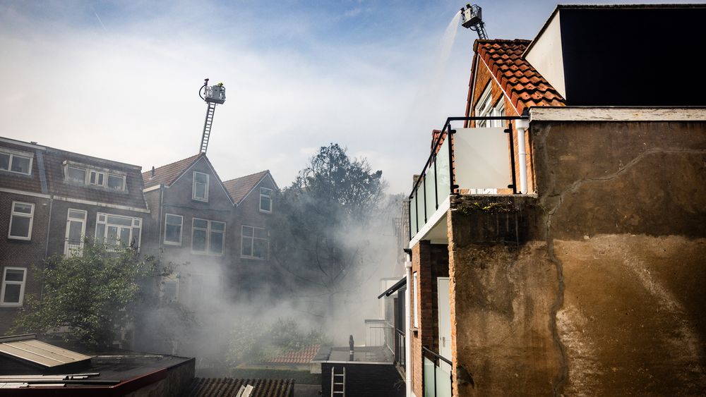 Grote brand in woning, vlammen slaan uit dak en rook in wijde omgeving ...
