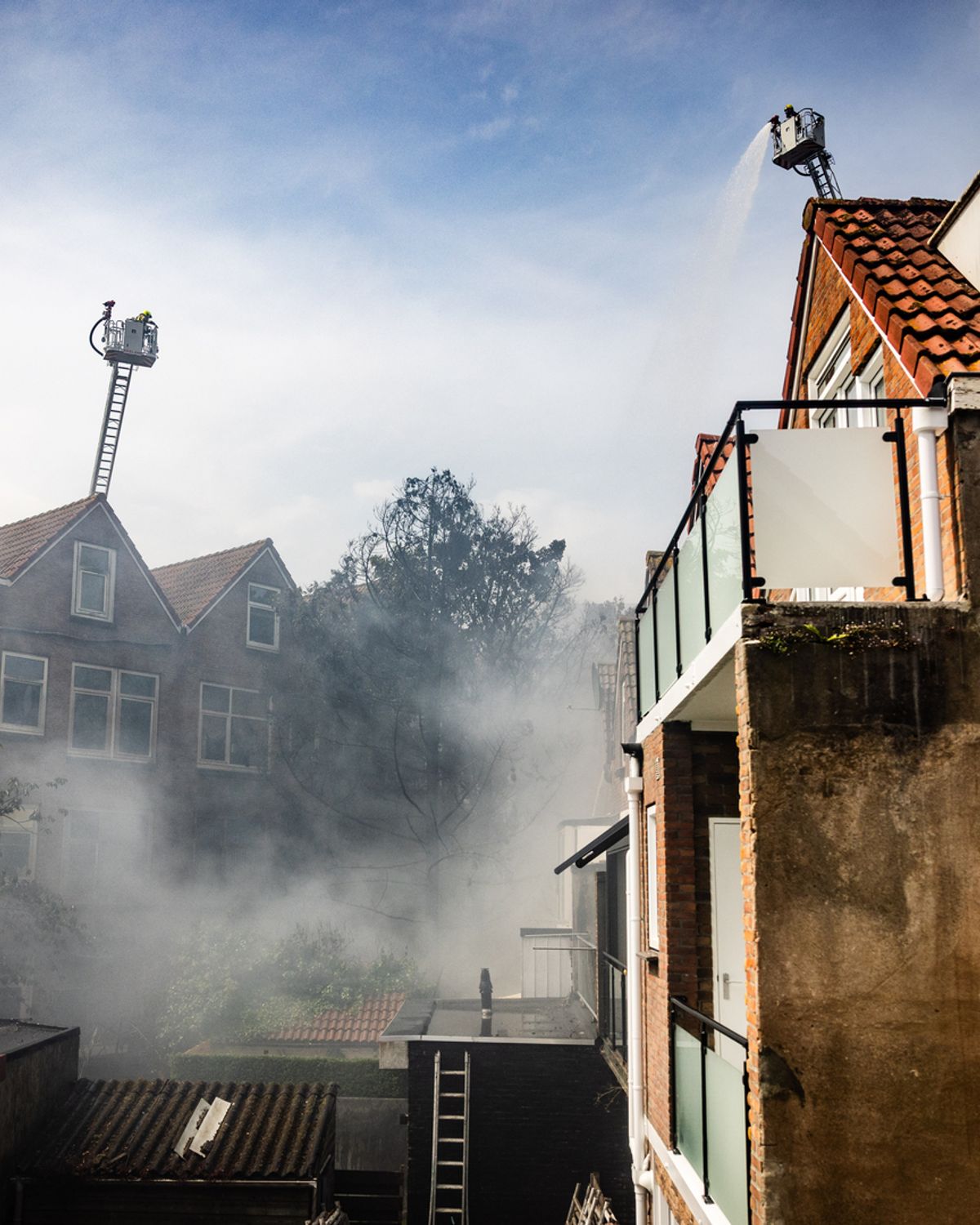 Grote brand in woning, vlammen slaan uit dak en rook in wijde omgeving ...